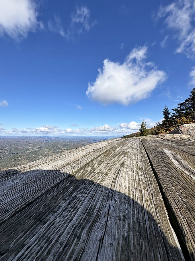 Summit wooden platform: Where weathered planks meet infinite sky, offering a front-row seat to Vermont's most spectacular natural show.