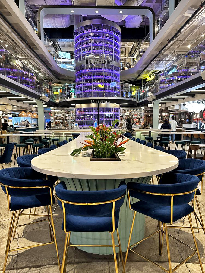 The sleek bar area combines industrial chic with warm lighting, creating the perfect backdrop for both serious conversations and frivolous gossip.