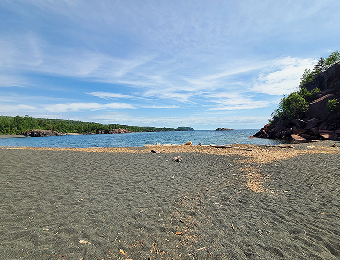 The charcoal-colored sand stretches along the shoreline, creating a beach experience unlike anything else you'll find in Minnesota.