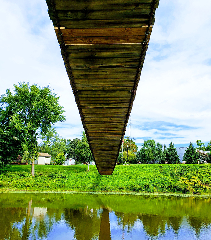 From below, the bridge's wooden planks create a geometric pattern against the sky &ndash; engineering simplicity that's stood the test of time.