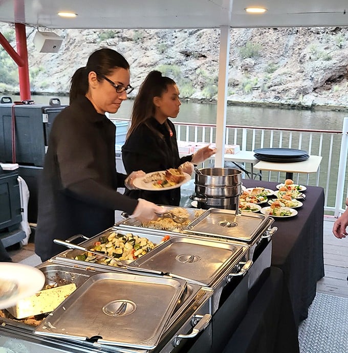 Staff prepare the evening buffet with care &ndash; each monthly menu rotation brings new flavors while maintaining crowd-pleasing favorites.