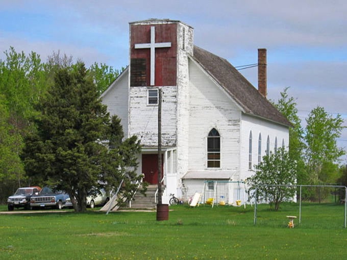 The white church stands as Dorothy's spiritual anchor, its simple architecture reflecting the straightforward faith that sustained generations of farming families.