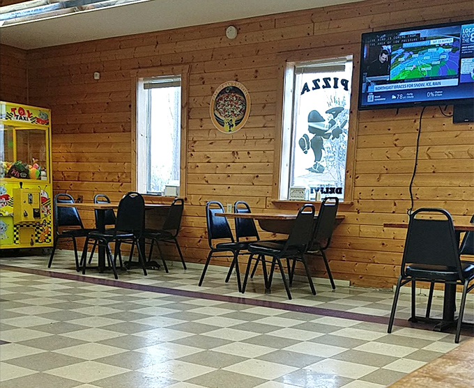 Simple seating and wood-paneled walls create a comfortable, family-friendly atmosphere where conversations flow as freely as the pizza.