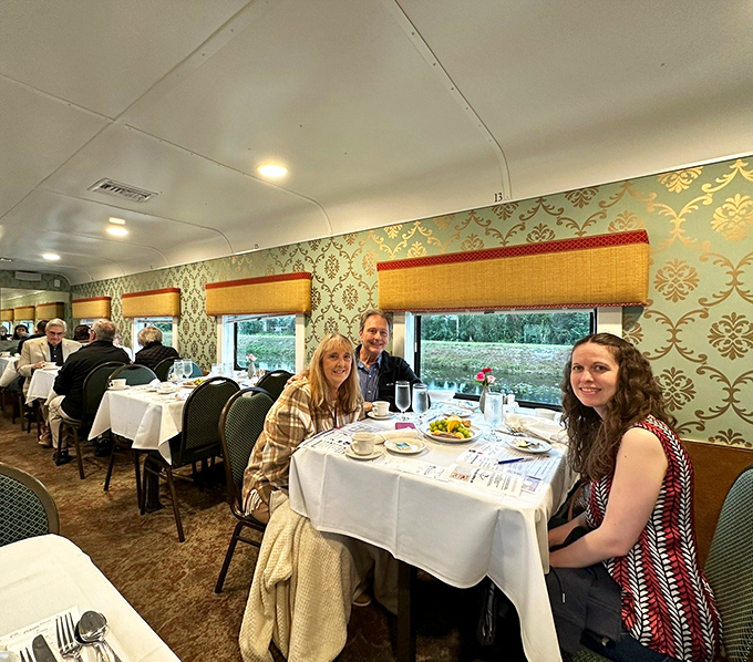 Happy diners enjoy the elegant atmosphere of the train's interior, where vintage charm meets modern comfort along the rails.