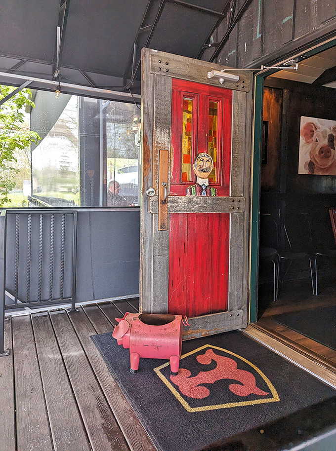 That red door with its whimsical face isn't just an entrance – it's a portal to a world where hospitality still reigns supreme.