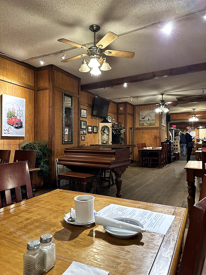 A piano waits silently in the corner, promising the possibility of impromptu entertainment between courses in this wood-paneled sanctuary.