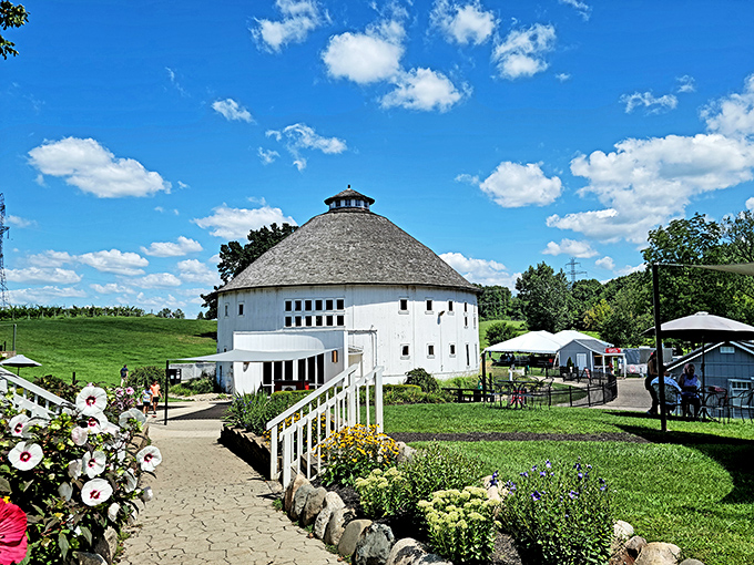 Postcard-perfect: The Round Barn's distinctive silhouette creates an irresistible photo opportunity, framed by gardens and set against Michigan's summer sky.