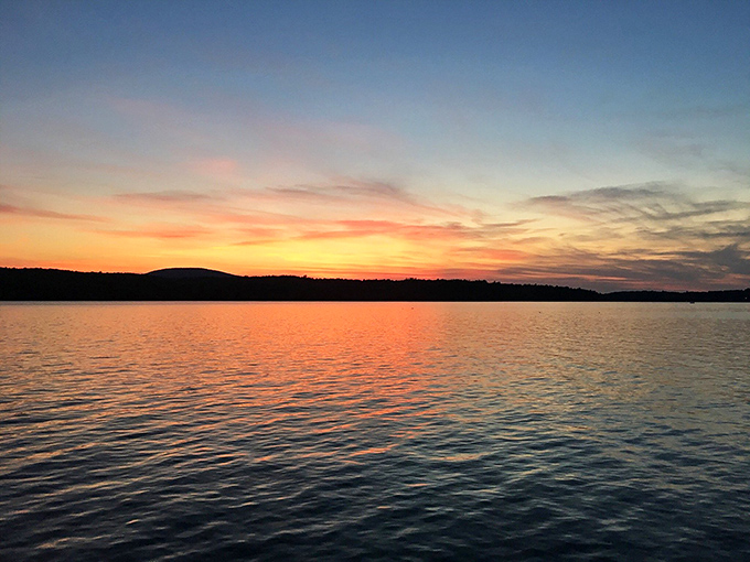 Sunset paints the water in shades that would make a professional artist weep with joy and immediately reach for their brushes.