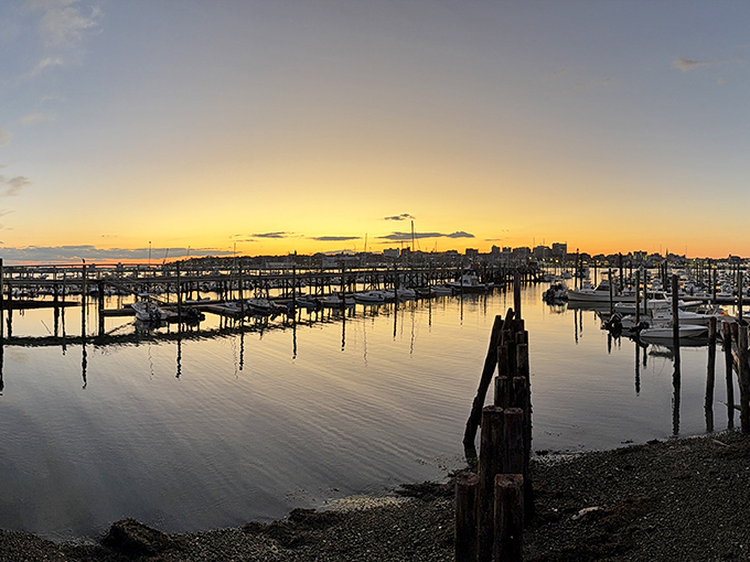 Golden hour transforms the harbor into liquid amber. Nature's showing off at sunset, making even the fishing boats look like they belong in a museum.
