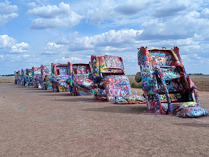 Ten Cadillacs stand buried nose-down in a Texas field, their paint-covered bodies creating a constantly changing art installation.