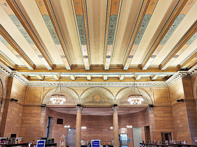 The coffered ceiling's intricate patterns and gold accents draw the eye upward, reminiscent of European palaces rather than Midwestern libraries.