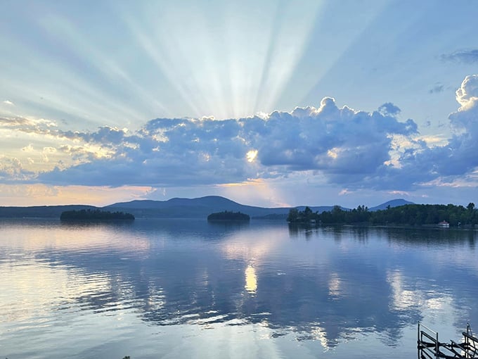 Golden rays burst through evening clouds, transforming Lake Memphremagog into a breathtaking display of natural light.
