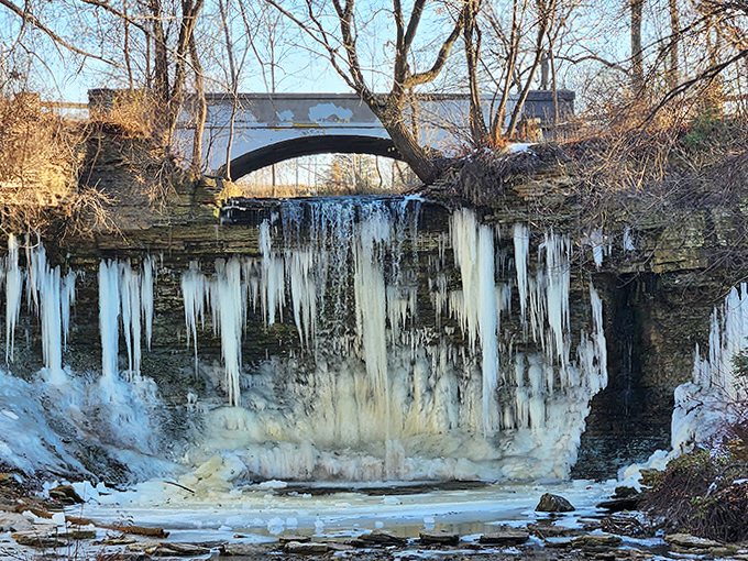 Winter's icy grip transforms the falls into a frozen curtain, suspended in mid-flow like nature hit the pause button.