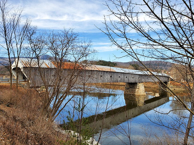 Fall's fiery palette complements the bridge's weathered timbers, creating a scene worthy of the most discerning New England calendar editor.