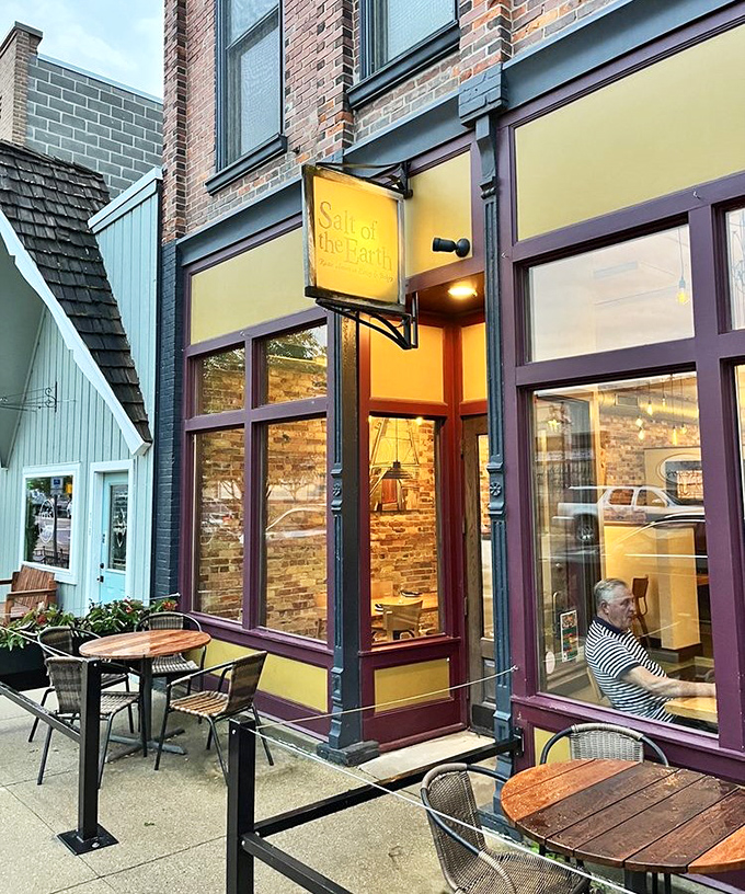 Outdoor tables invite diners to enjoy Michigan's perfect summer evenings, with the restaurant's warm glow spilling onto the sidewalk.
