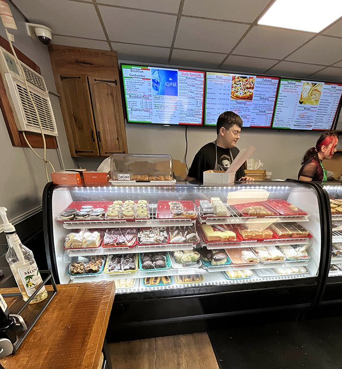 A dessert case packed with temptation, watched over by a busy team keeping the sweet cravings flowing.