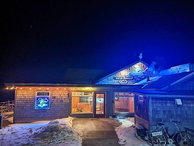 As darkness falls, the Angry Trout transforms into a beacon of warmth against Minnesota's night sky, its neon glow promising seafood sanctuary.