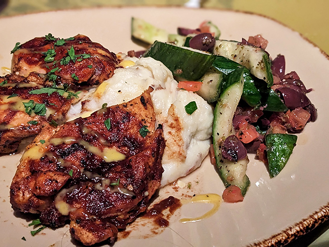 Perfectly grilled chicken pairs with Mediterranean-inspired sides, proving T-Rex Cafe isn't just about theatrical dining but quality ingredients too.