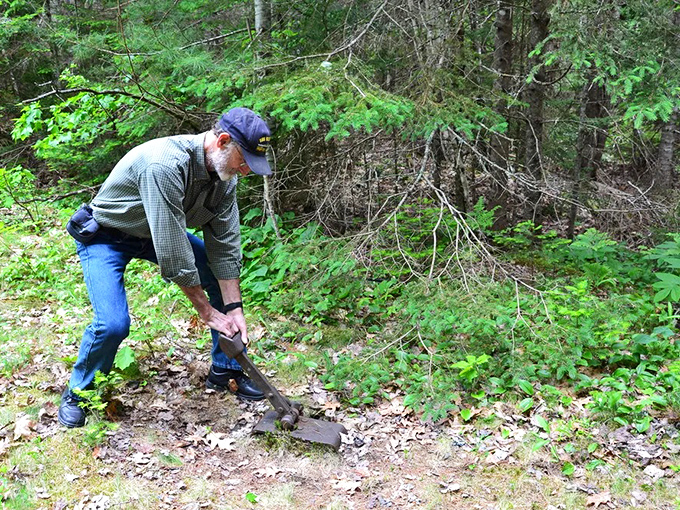History unearthed: A dedicated volunteer carefully excavates remnants of the old railway, preserving Maine's transportation heritage.