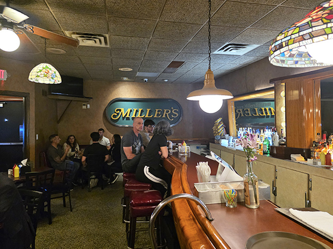 Patrons gather at the bar, participating in a Michigan dining tradition that has remained steadfastly authentic while the world changed around it.