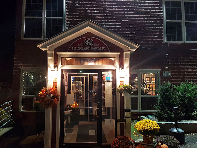 The welcoming entrance, adorned with seasonal flowers, invites you into a world where Italian tradition meets Maine hospitality.