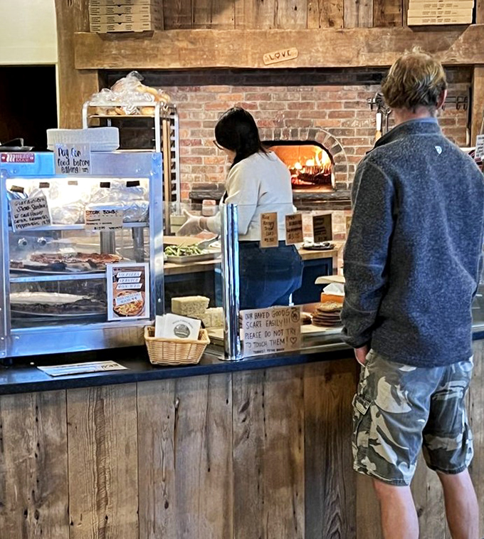 Order Counter: The moment of anticipation – where hungry patrons watch their wood-fired dreams come to life in the fiery brick oven.
