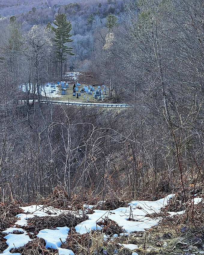 The cemetery nestled below offers a peaceful perspective on how communities exist regardless of the lines drawn on official maps.