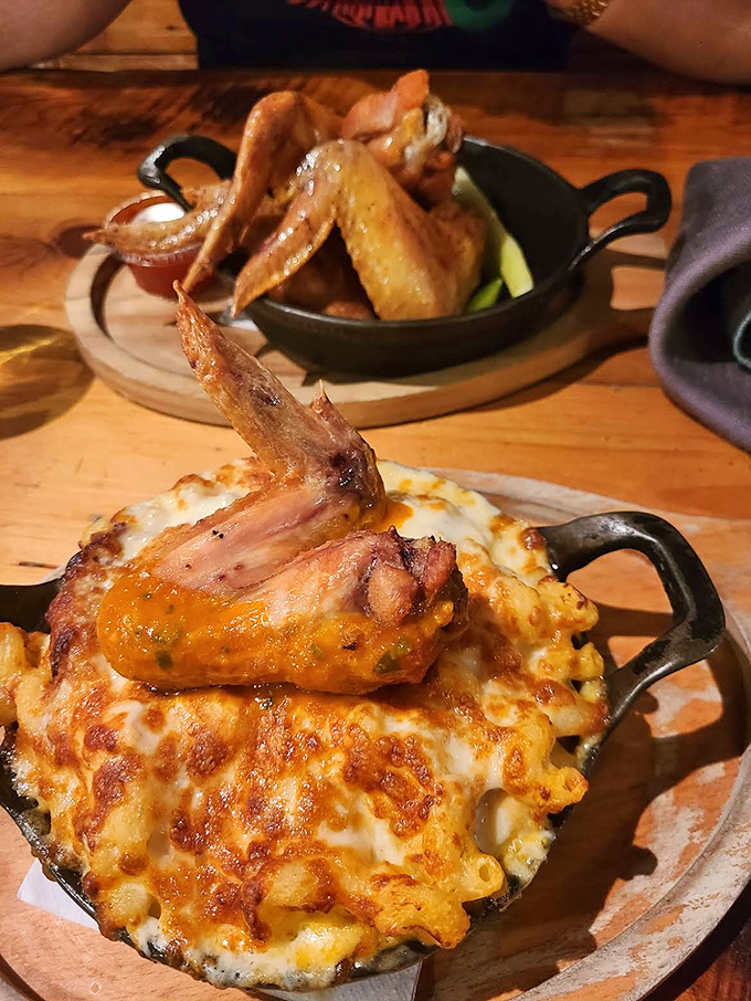 Buffalo chicken mac and cheese brings the heat with a wing perched atop like it's surveying its cheesy kingdom below.