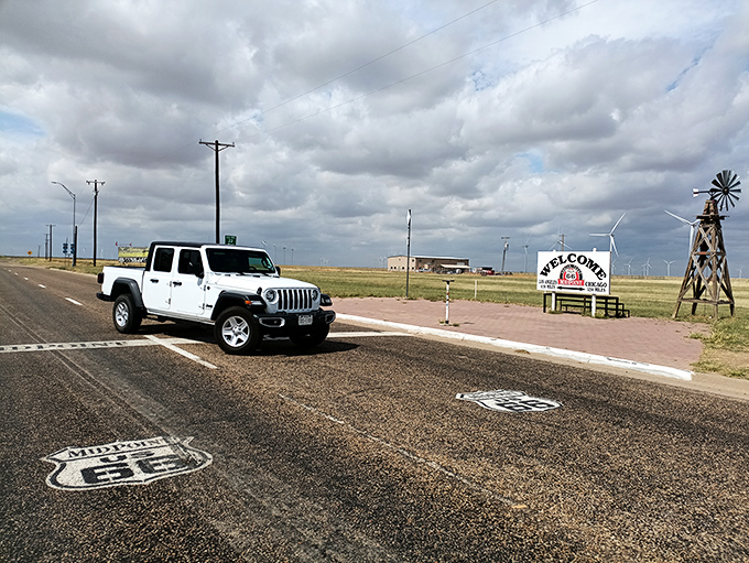 The midpoint windmill turns slowly in the Texas breeze, marking the spot where eastbound and westbound travelers are equally far from home.