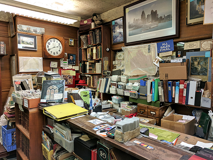 The counter area resembles a bookish archaeological dig site where organization is more theoretical concept than actual practice, and that's perfect.
