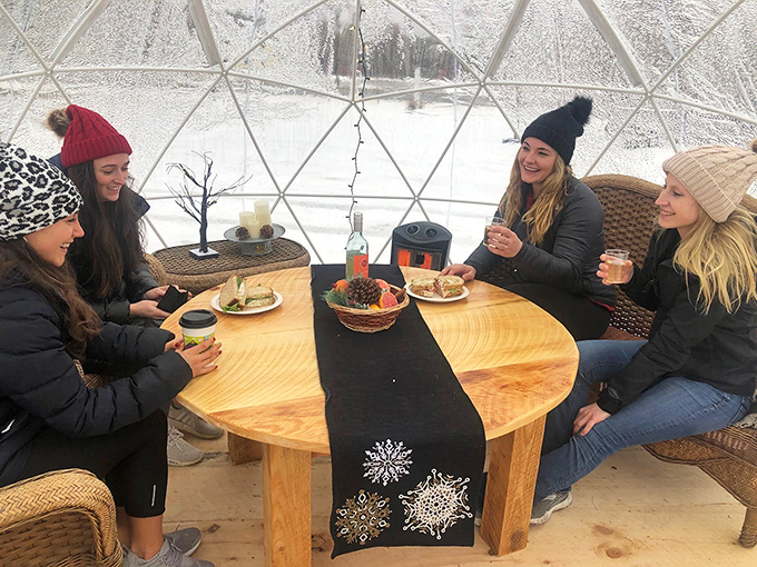 Friends gather in the cozy confines of a heated dome, proving that winter socializing doesn't have to mean crowded indoor spaces or freezing patios.