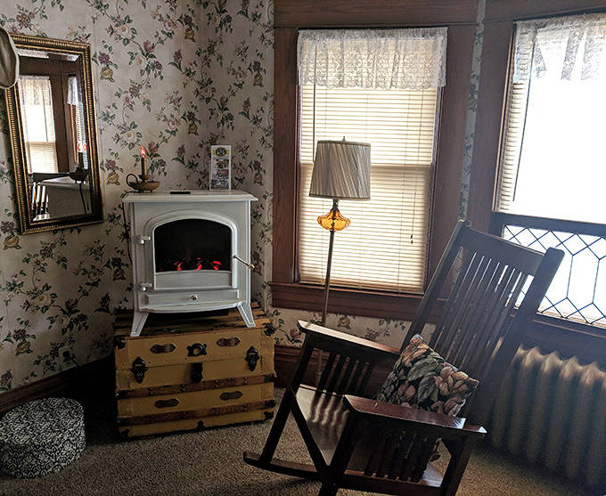 Cozy up by the white electric stove in this floral suite, the perfect spot for a relaxing evening of reading.