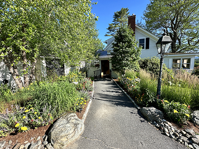 The entrance pathway, lined with seasonal blooms, invites guests to leave the ordinary world behind and enter culinary paradise.