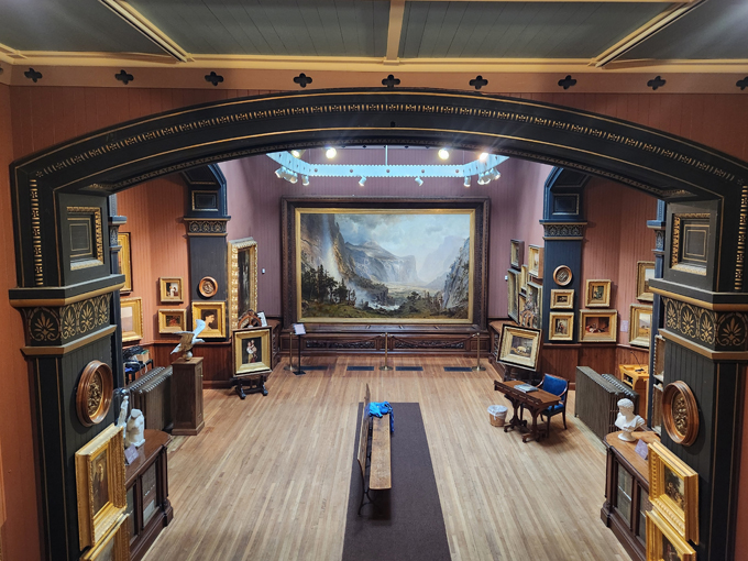 The gallery floor and ornate archway frame that centerpiece painting perfectly, creating a space that feels both grand and intimate.