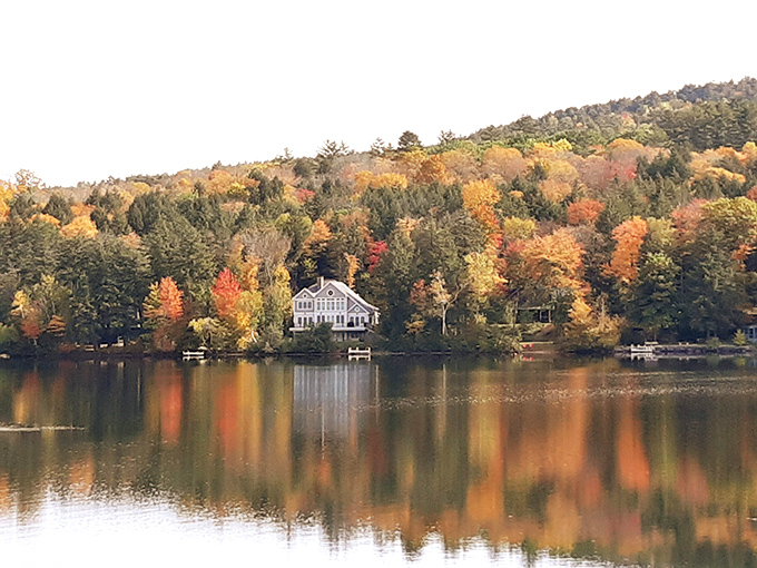 Autumn's reflection creates a double feature of fall splendor, with lakeside homes enjoying front-row seats to nature's most colorful production.