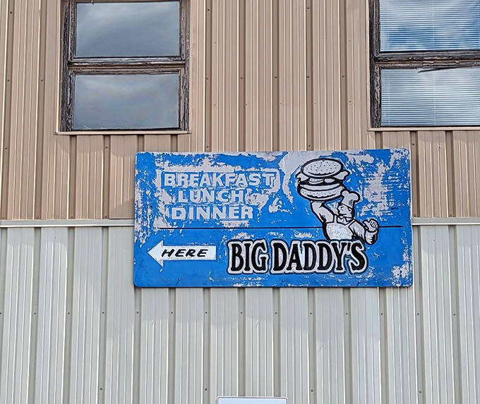 A weathered blue sign points the way to burger paradise, showing that the best directions in life often lead to comfort food.