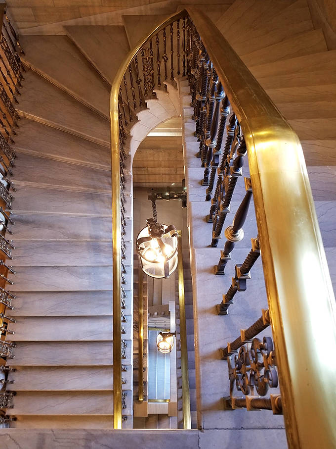 Brass railings gleam against marble stairs in this architectural showstopper, where each step has been worn by generations of knowledge-seekers.