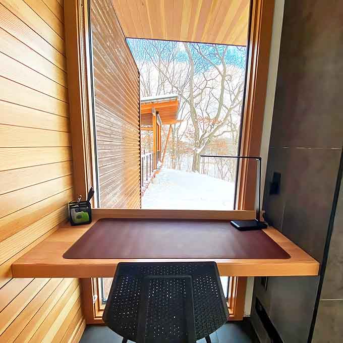 A compact workspace tucked by the window proves that even paradise needs a spot for checking email, though good luck concentrating with that view demanding your attention.