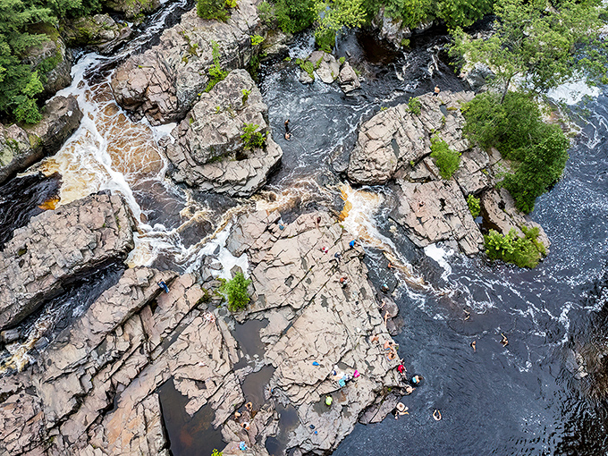From above, the river's path reveals nature's artistry, as water carves through resistant rhyolite creating pools where brave swimmers cool off in summer.