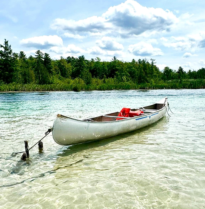 Simplicity meets splendor &ndash; a lone canoe rests on Torch Lake's famous sandbar, where the water's clarity reveals every ripple in the sandy bottom.
