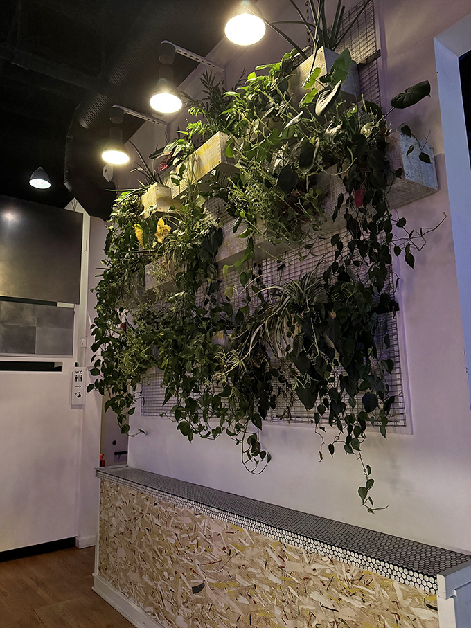 An impressive living wall of cascading plants brings unexpected greenery to the gaming space, proving nature and technology can coexist beautifully.