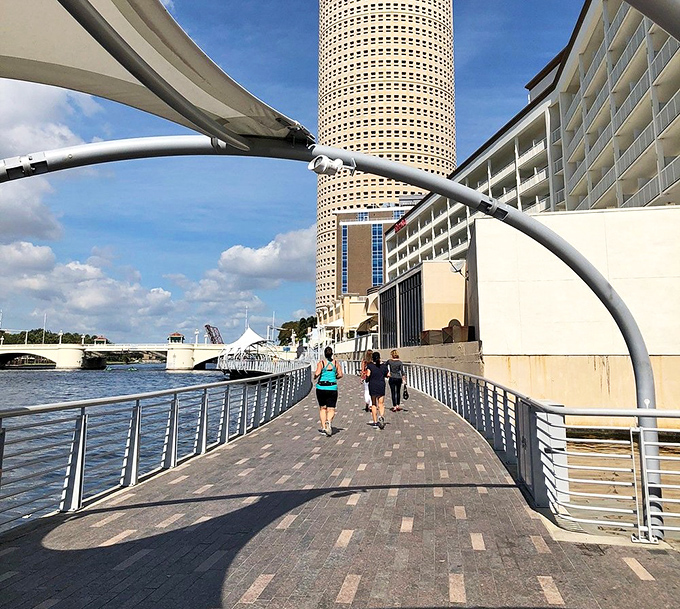 Morning joggers take advantage of the Riverwalk's smooth pathways, getting their exercise with Tampa's iconic cylindrical tower as motivation.