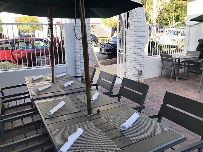 The outdoor patio offers al fresco dining under Florida skies, where each table setting promises an experience beyond mere eating.