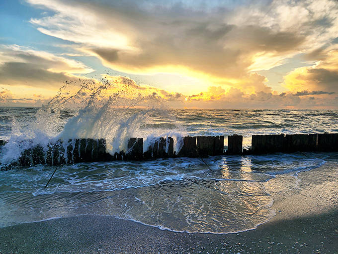 Wooden breakwater: Waves crash dramatically against the weathered wood barrier, nature and human engineering in their eternal dance.