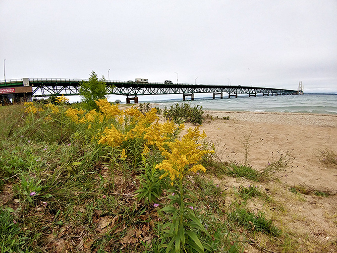 Sandy pathways lead travelers toward breathtaking views of the Mighty Mac, inviting moments of contemplation before crossing between Michigan's two worlds.