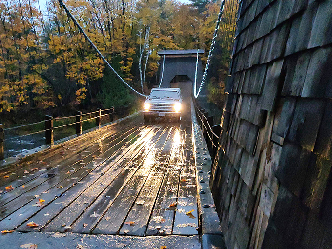 Twilight crossing: headlights illuminate the wooden planks, creating a magical evening passage across the historic span.