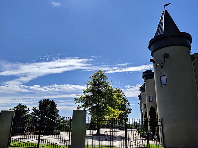 The castle's entrance beckons through ornate gates, promising visitors an experience where Michigan hospitality meets fairy tale grandeur.