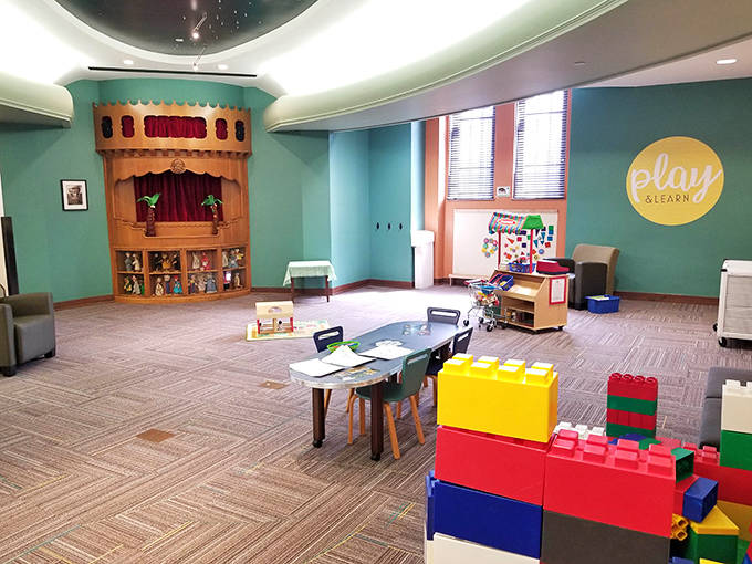 The children's area bursts with color and creativity, featuring a puppet theater and building blocks to nurture young imaginations.