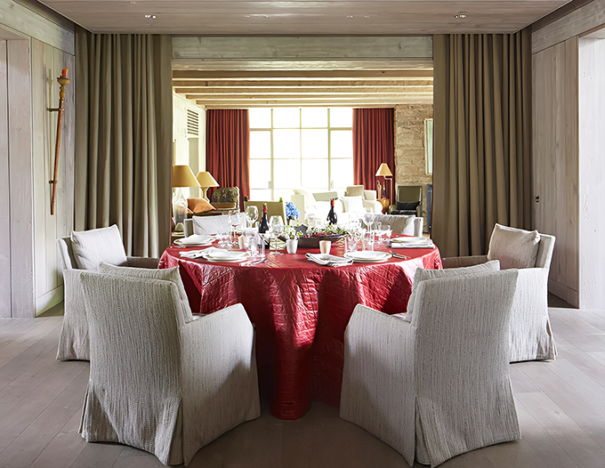 A circular table draped in rich red fabric creates a dramatic focal point for memorable meals and lingering conversations.