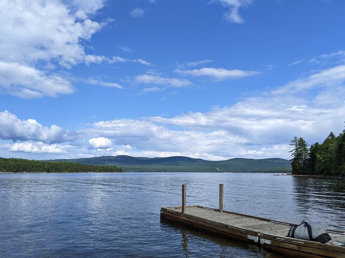 A simple wooden dock extends invitation to waters so clear you can count pebbles beneath the gentle ripples.